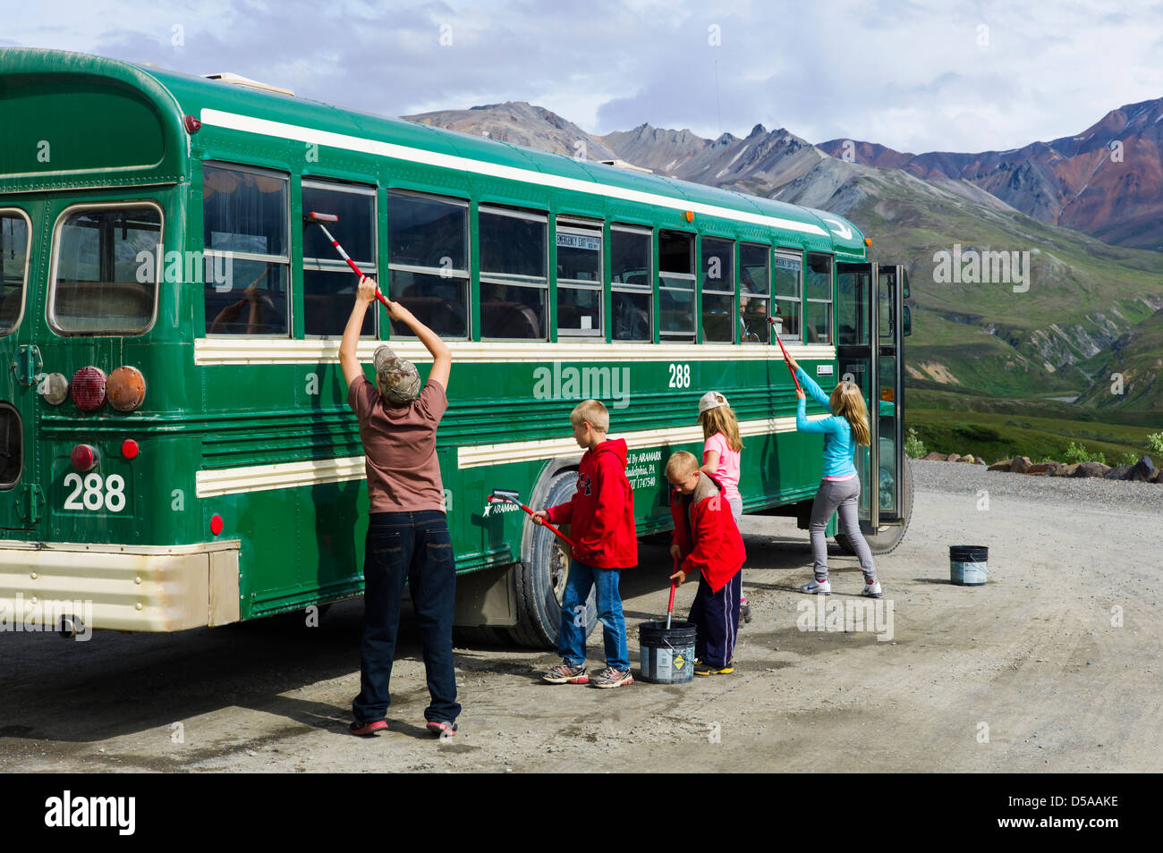 Young park visitors help clean the dust from the shuttle bus windows ...