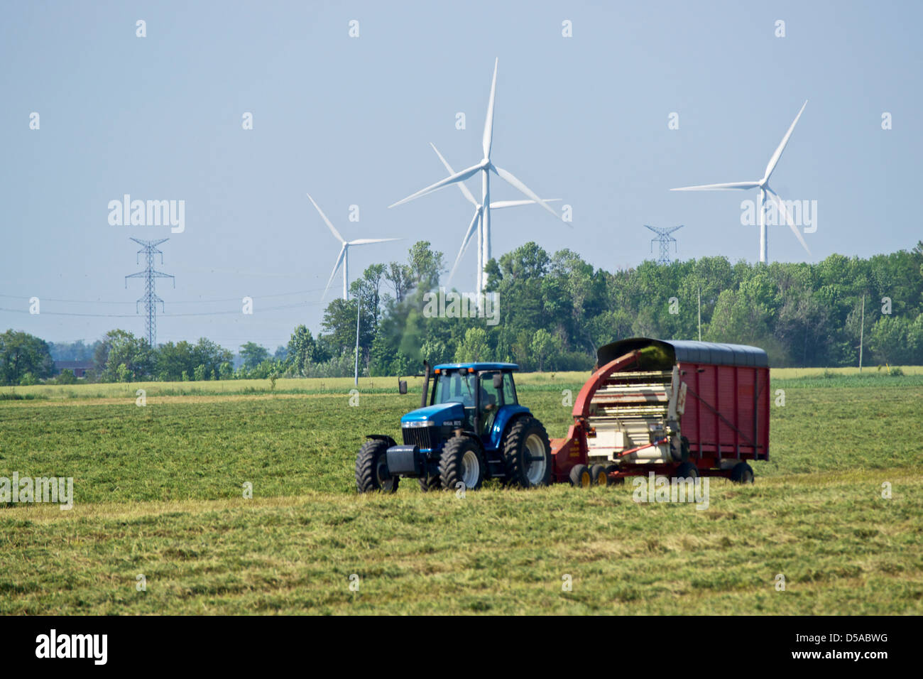 Tractor working in a farm with wind turbines in the distance near ...