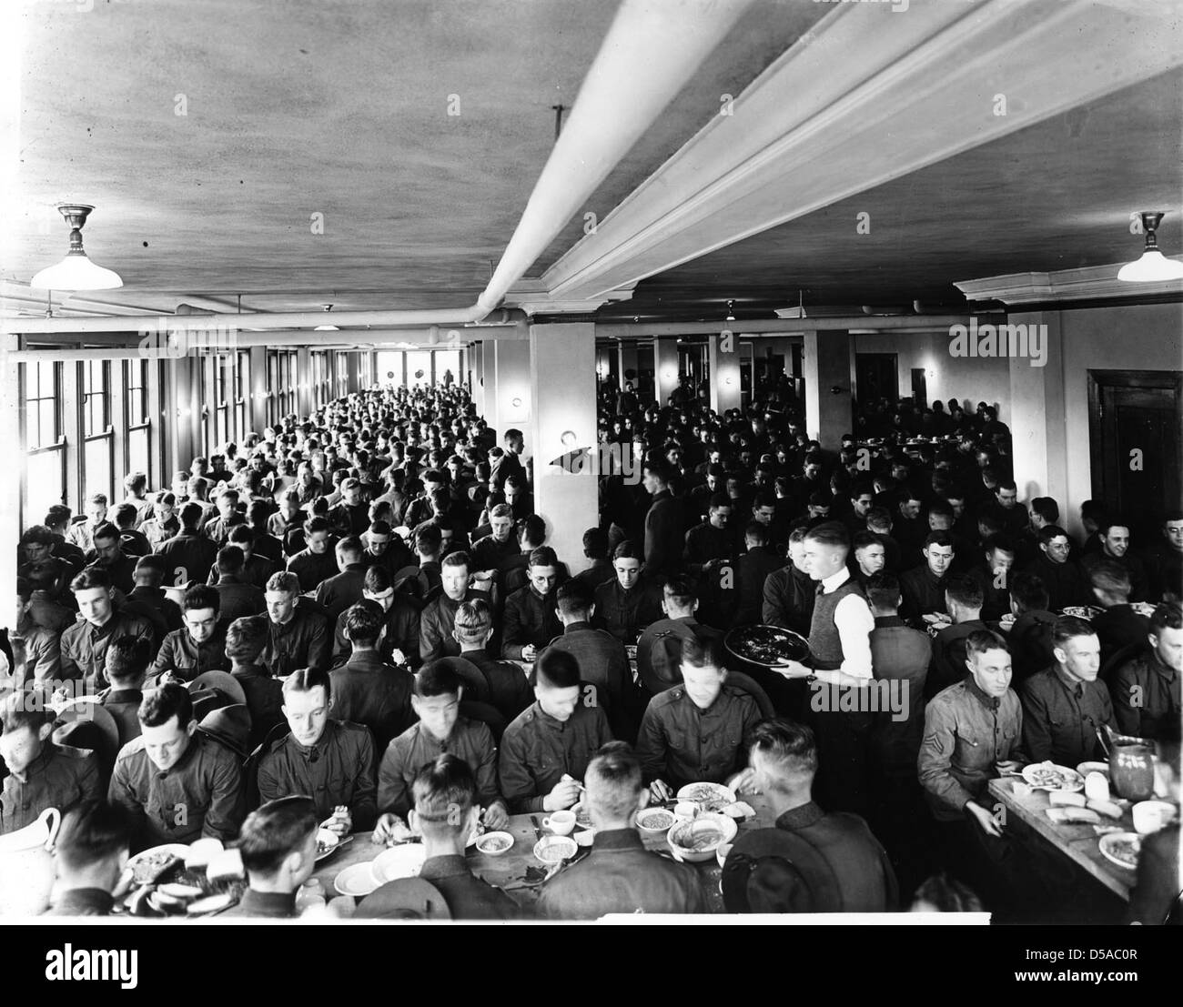 Servicemen are seen eating in a home economics cafeteria during 1917-18 ...