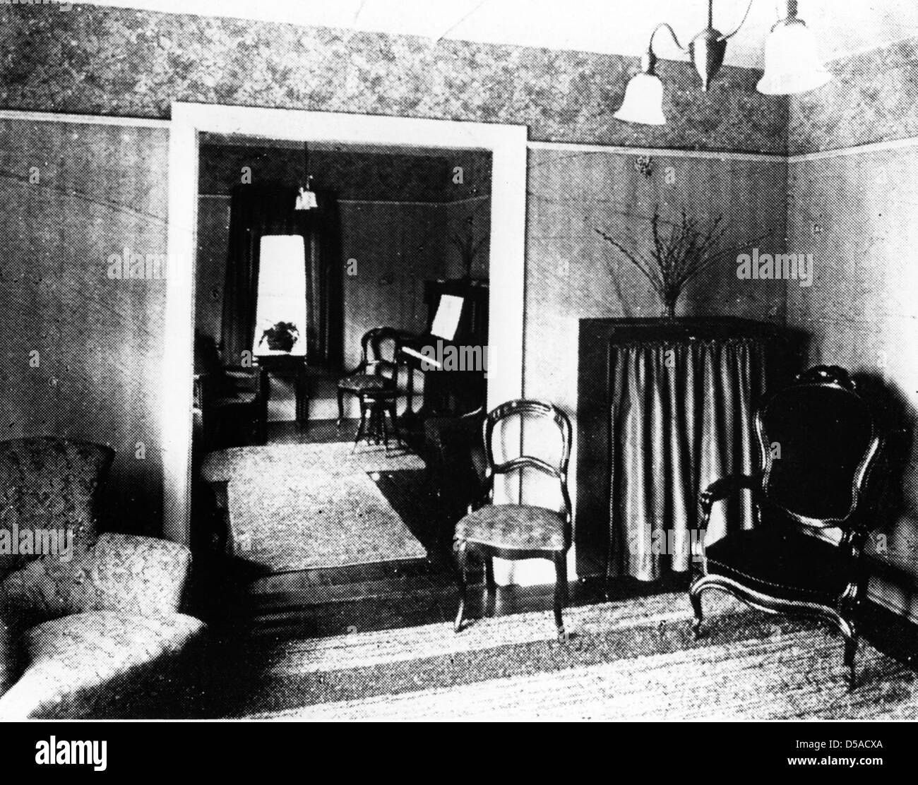 This photograph shows the living room of a lodge from around 1920. The ...