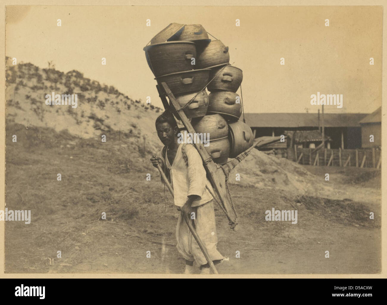 A porter, shown carrying clay pots strapped to an A-frame on his back ...