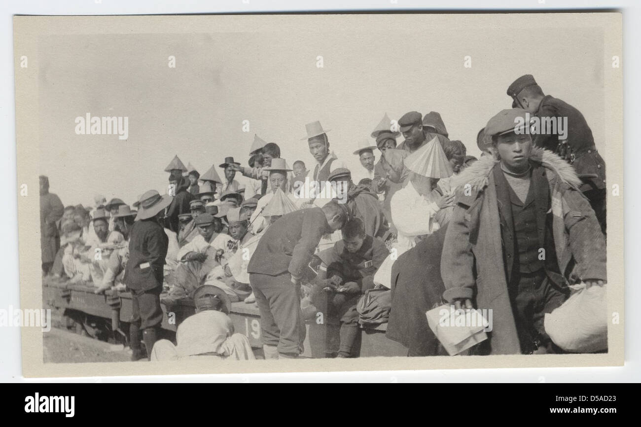 A photograph showing a group of passengers aboard a train. The image ...
