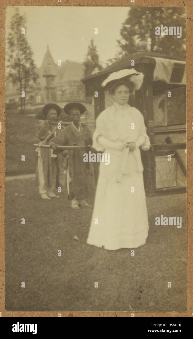 A Western woman is shown with Korean bearers carrying a palanquin, a ...