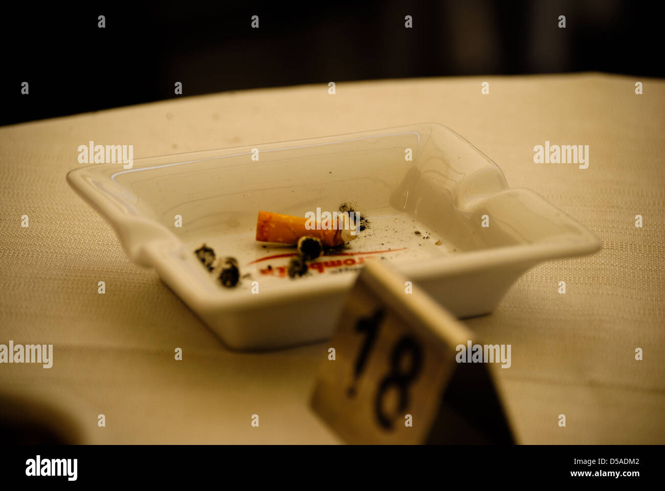 A burnt out cigarette butt in an ash tray at a restaurant Stock Photo ...
