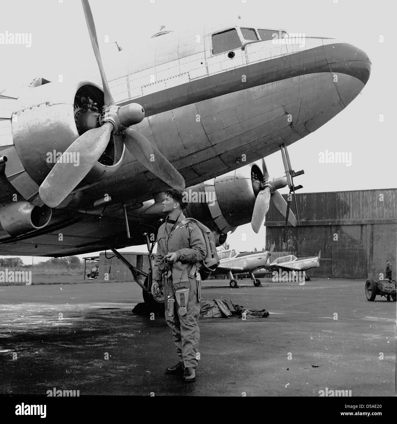 Historical 1950s. Flying. Young student pilot in flying clothing looks ...