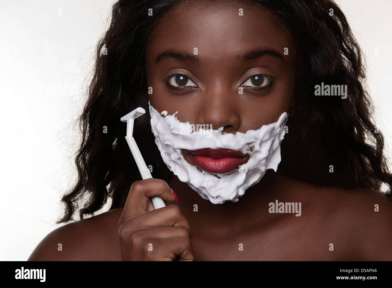 Beautiful young black african american woman shaving her face with a ...