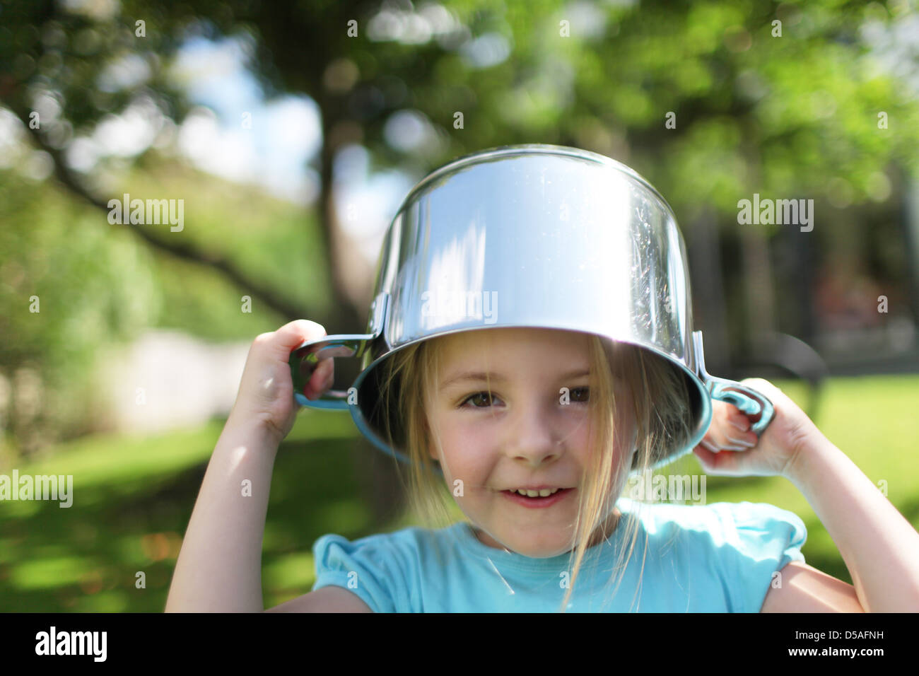 Handewitt, Germany, a girl with a cooking pot on his head in the garden ...