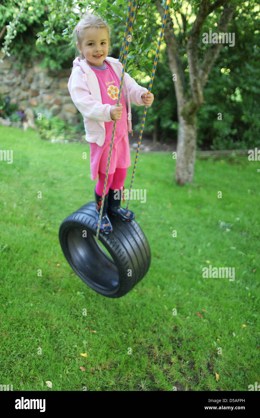 Handewitt, Germany, a girl standing on a tire swing Stock Photo - Alamy