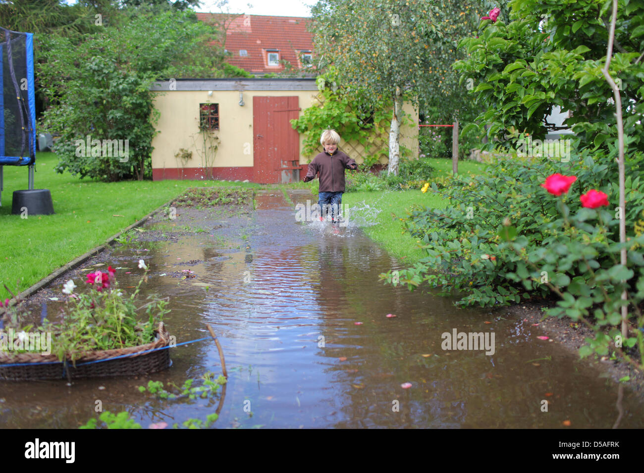 Handewitt, Germany, a boy runs in rubber boots through an over flooded ...
