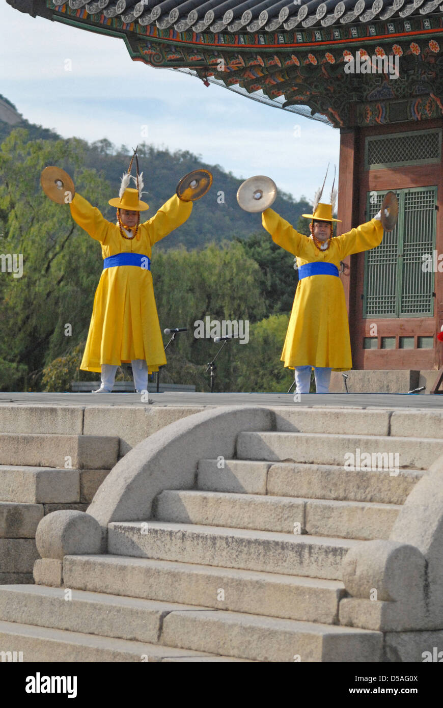 Two men in royal court costume playing symbols, Gyeongbokgung Palace ...