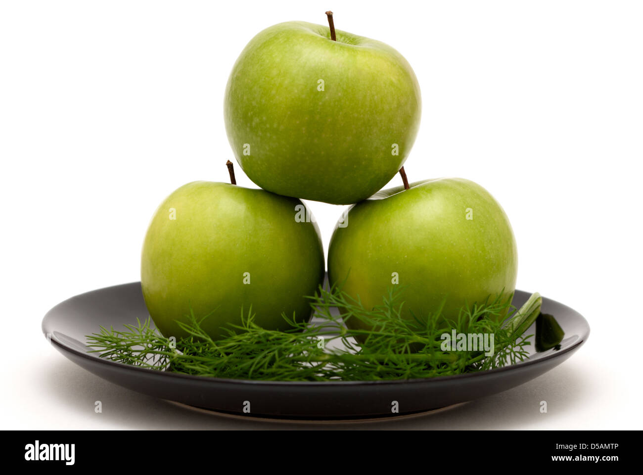 Three apples with dill on a black plate Stock Photo - Alamy