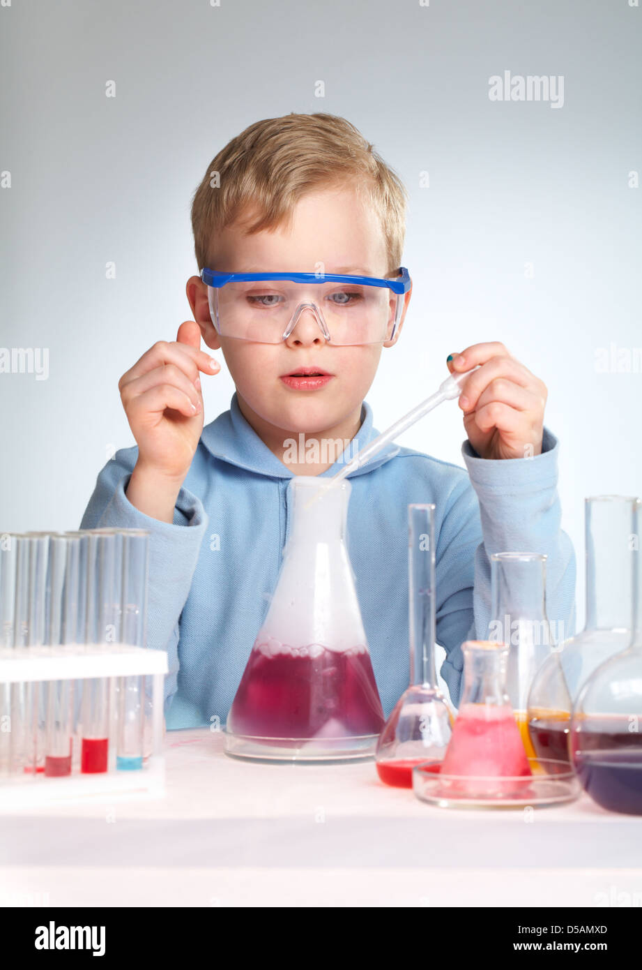 Vertical shot of a school scientist being curious about chemical ...