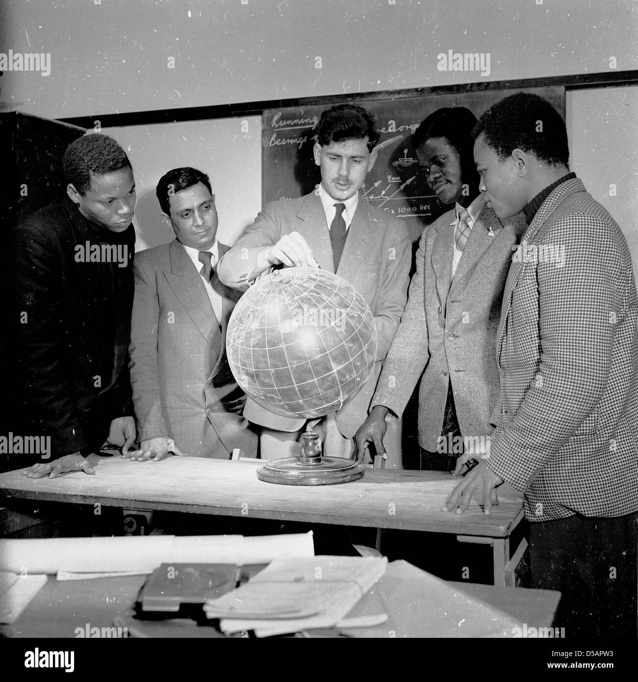 Historical 1950s. Flying. Flight instructor shows a small group of ...