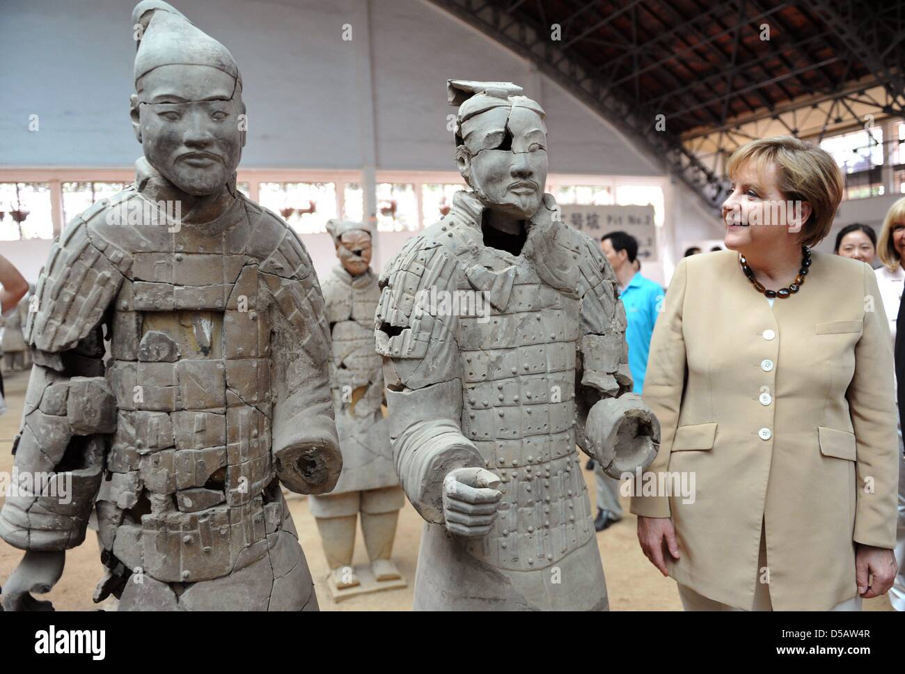 German Chancellor Angela Merkel smiles with two soldiers of the ...