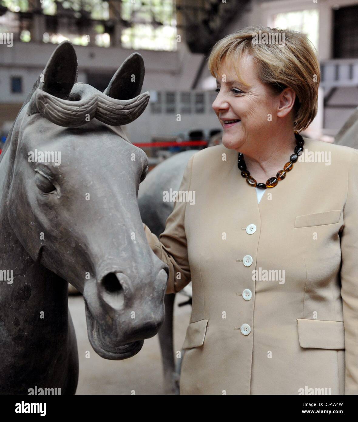 German Chancellor Angela Merkel smiles next to a horse of the ...