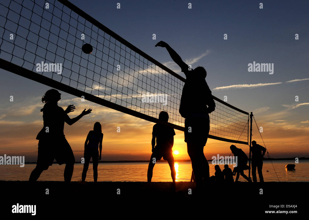 People play volleyball during a phantastic sunset near Noer, Germany ...