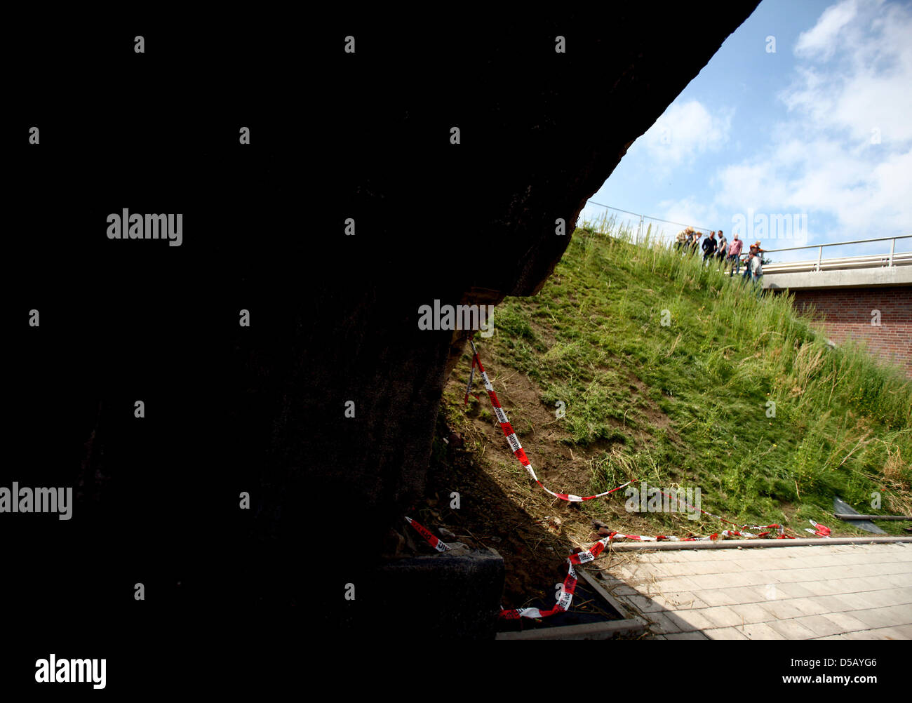 People mourn near the tunnel that formed the entrance to Love Parade ...