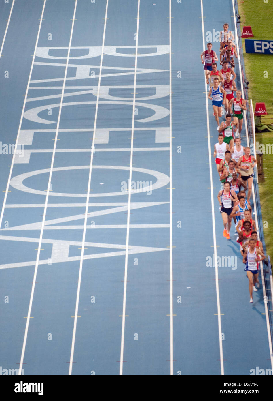 Runners of the 10,000 metres Men Final pass by the lettering 'Barcelona ...