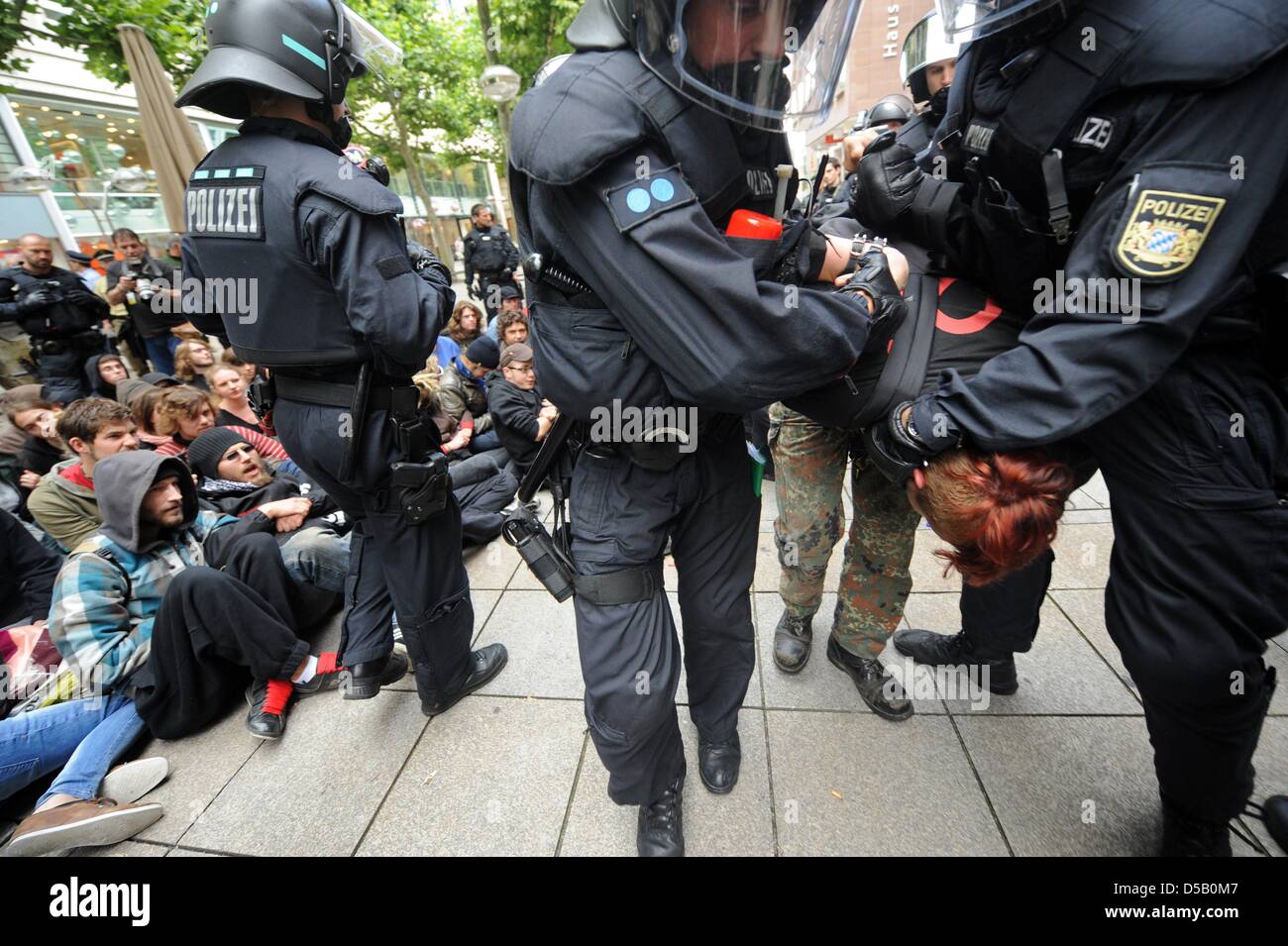 Police forces in riot gear carry away a protestor during a rally ...