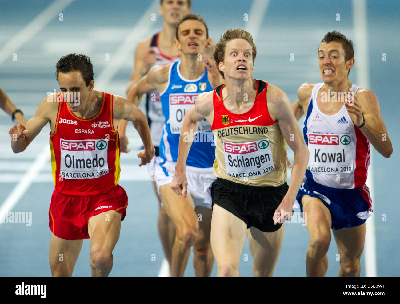 German runner Carsten Schlangen (C) crosses the finish line, taking ...