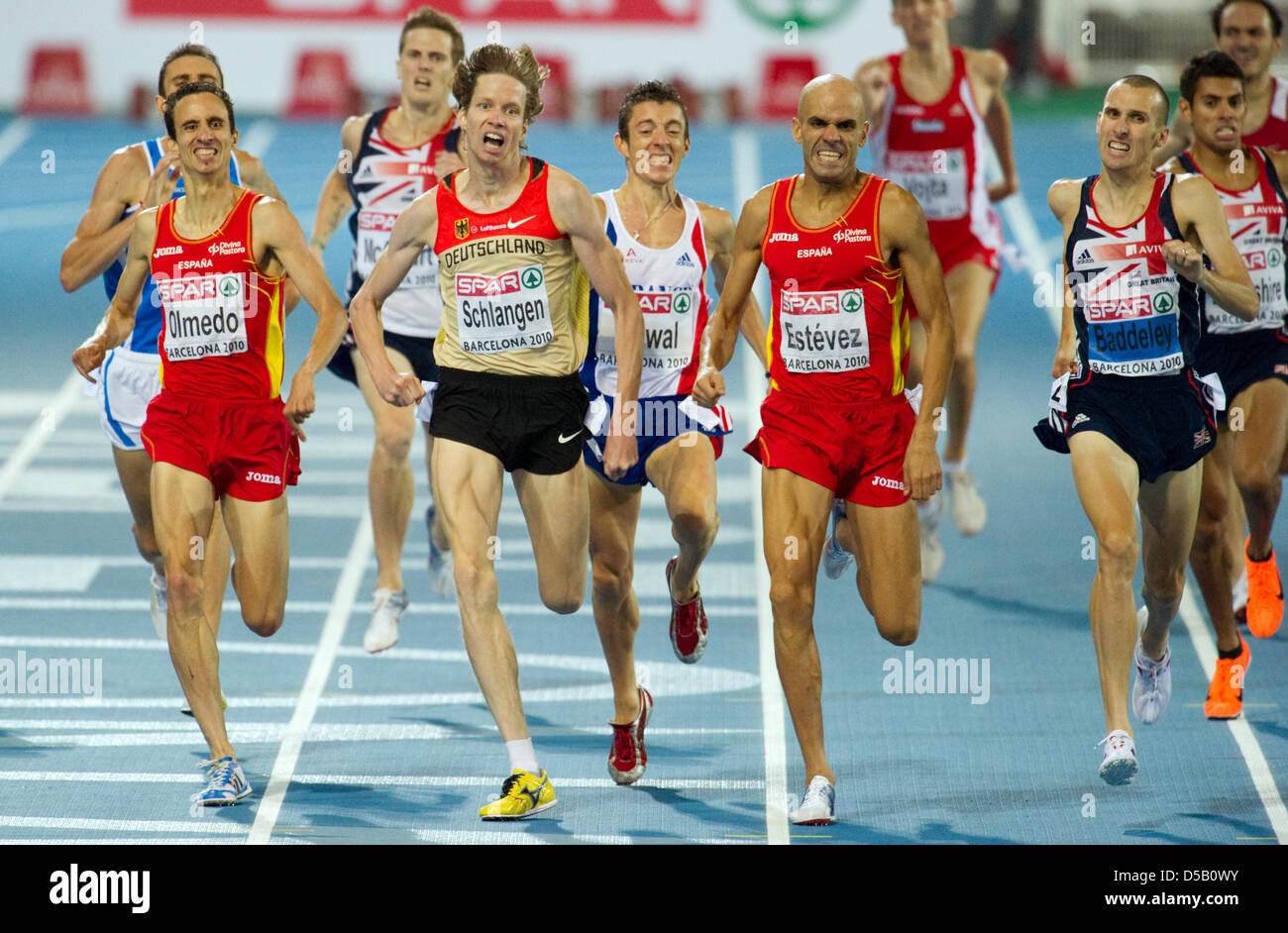German runner Carsten Schlangen (C) crosses the finish line, taking ...