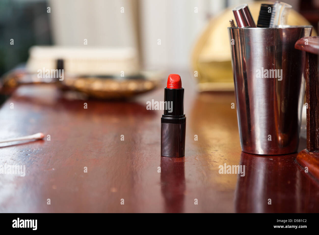 Wooden make-up table with red lipstick Stock Photo - Alamy