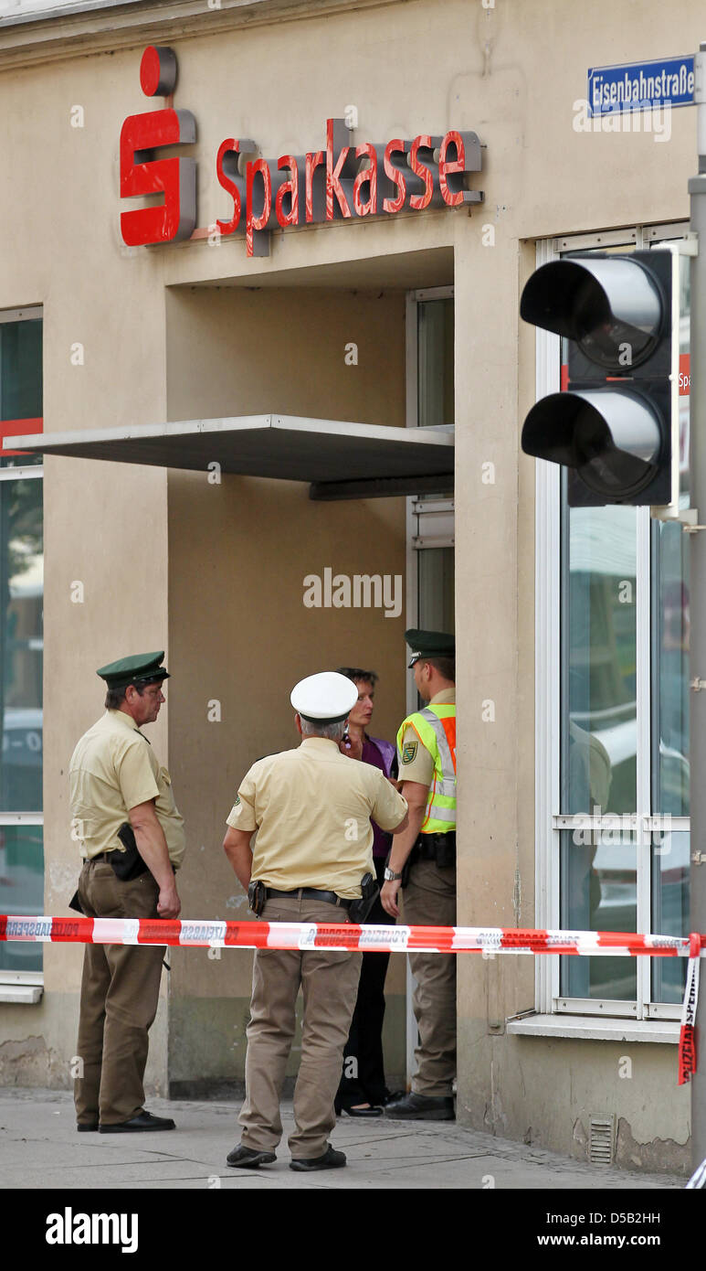 Police officers stand in front of a savings bank in Leipzig, Germany ...