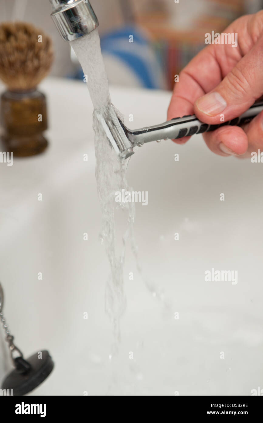 Closeup of hand cleaning shaving blade in water Stock Photo - Alamy
