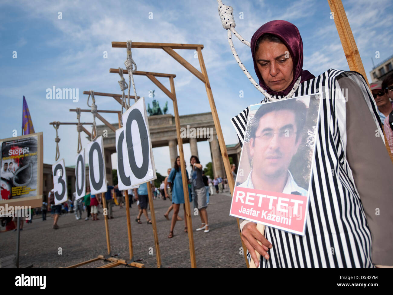 A woman stands in front of the Brandenburg Gate with a sling around her ...