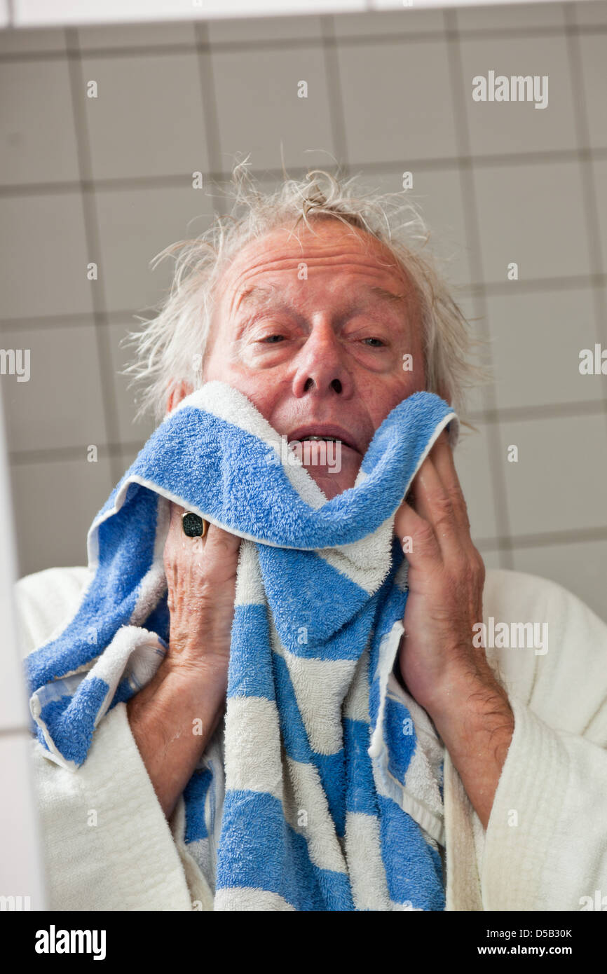 Senior man drying his face with towel after shaving Stock Photo - Alamy