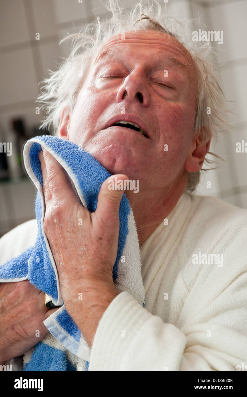 Senior man drying his face with towel after shaving Stock Photo - Alamy