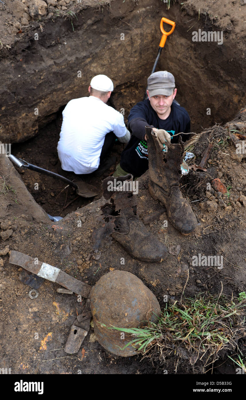 Staff members of the German war cemetery aid association recover the ...