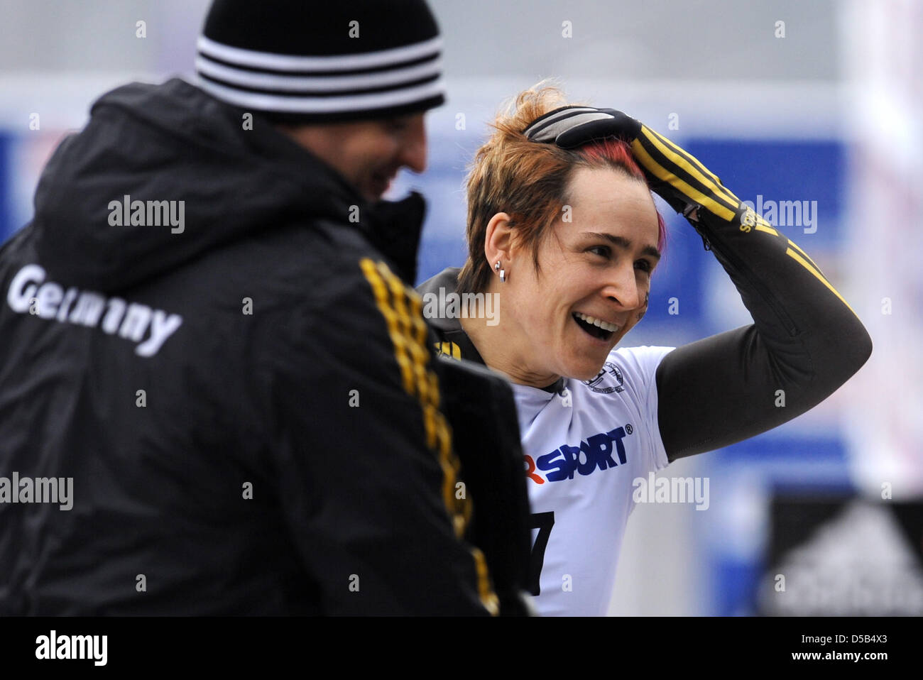 German Skeleton pilot Kerstin Szymkowiak (R) touches her forehead after ...