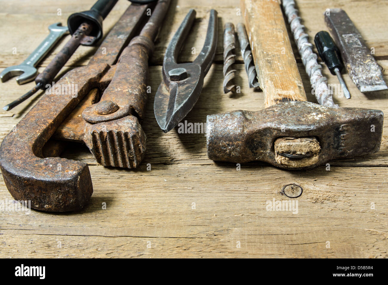 Old tools (hammer, drills, wrench, scissors for metal) on wooden ...