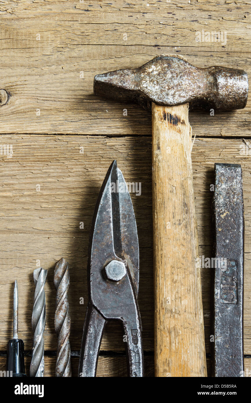 Old tools (hammer, scissors for metal, drills) on wooden background ...