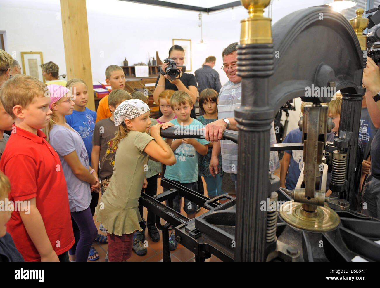 Schoolchildren try out a manual printing press at the Printing Museum ...