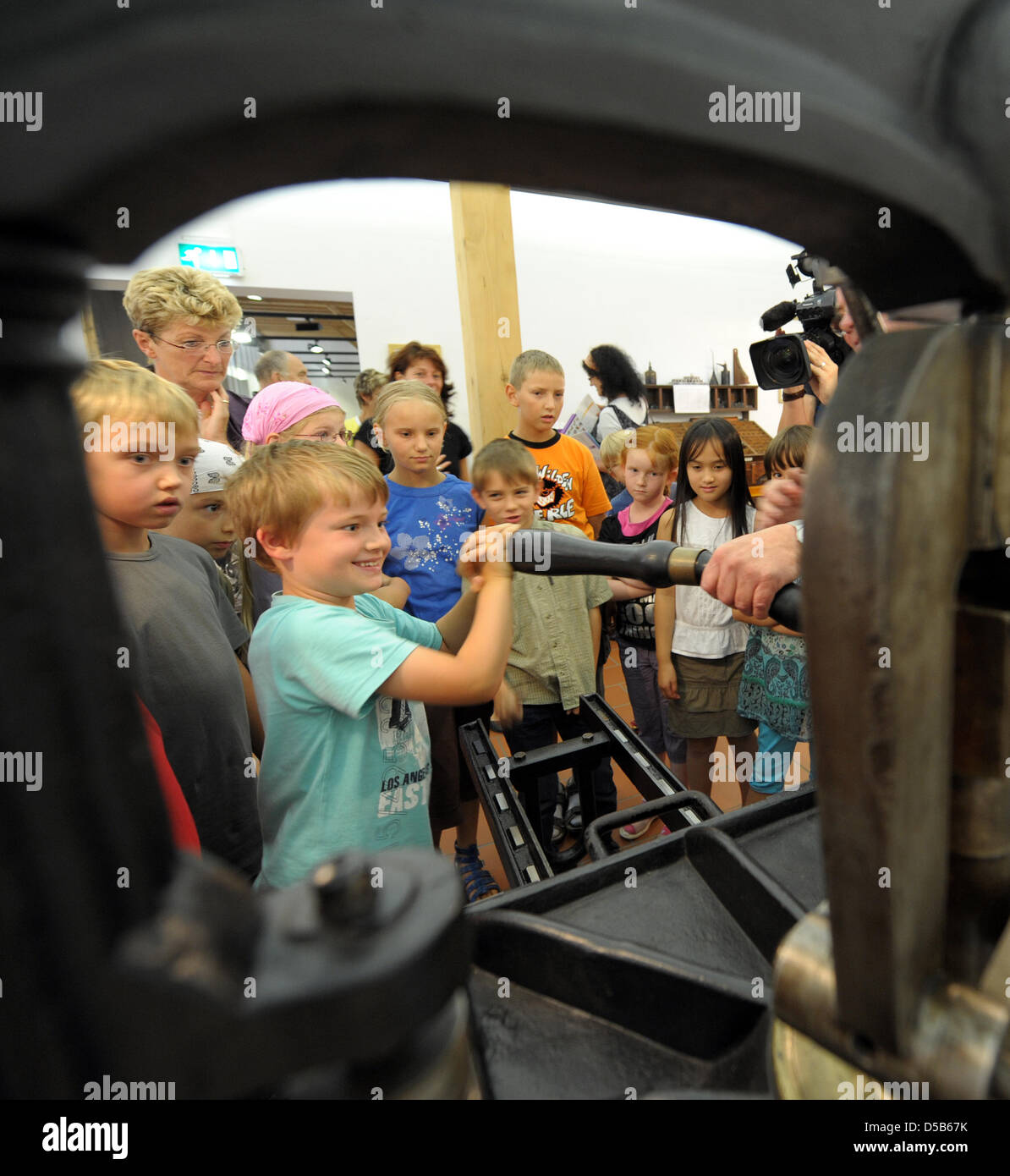 Schoolchildren try out a manual printing press at the Printing Museum ...