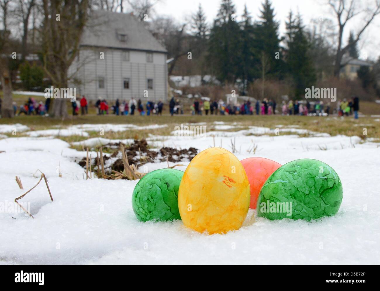 Weimar, Germany. 28th March 2013. Coloured Easter eggs lie in the snow ...