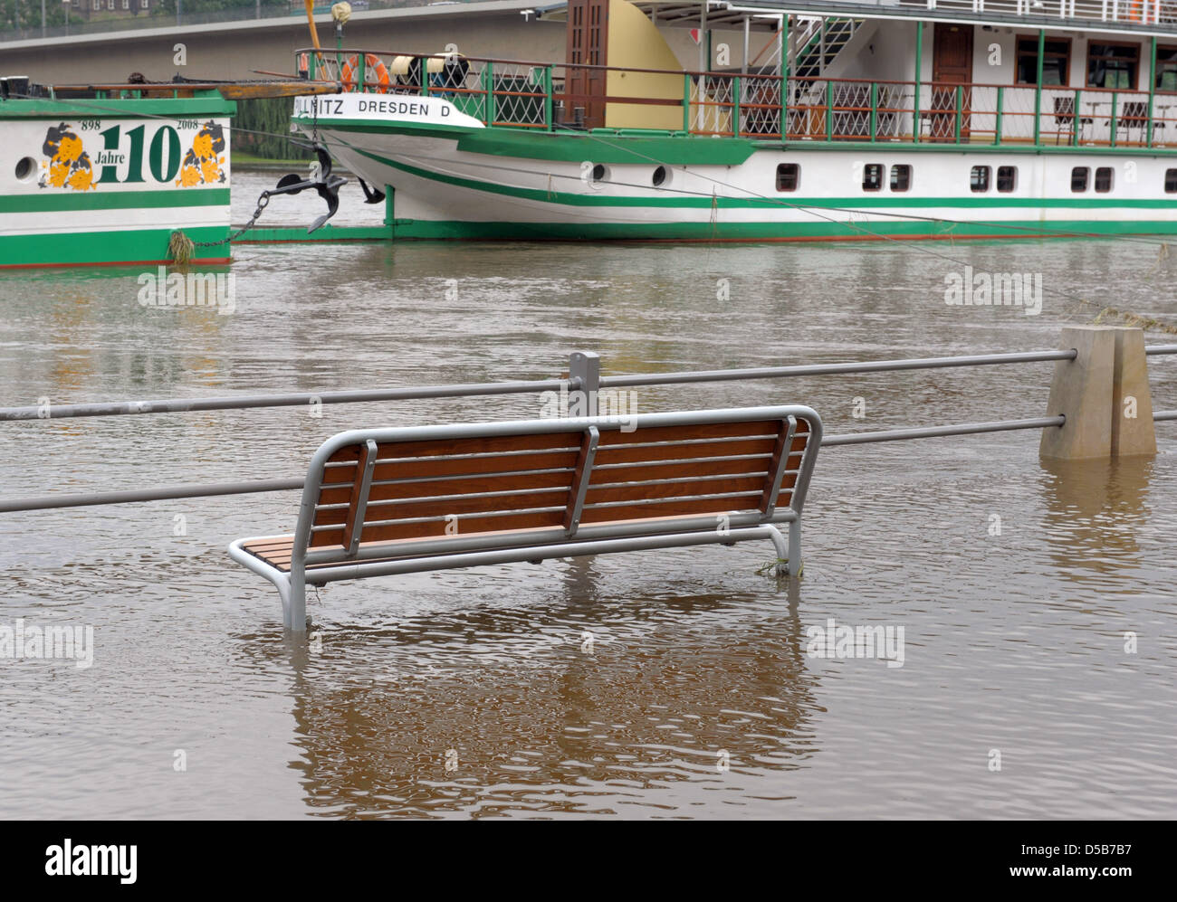 A bench stands submerged in flood water on the embankment of the River ...