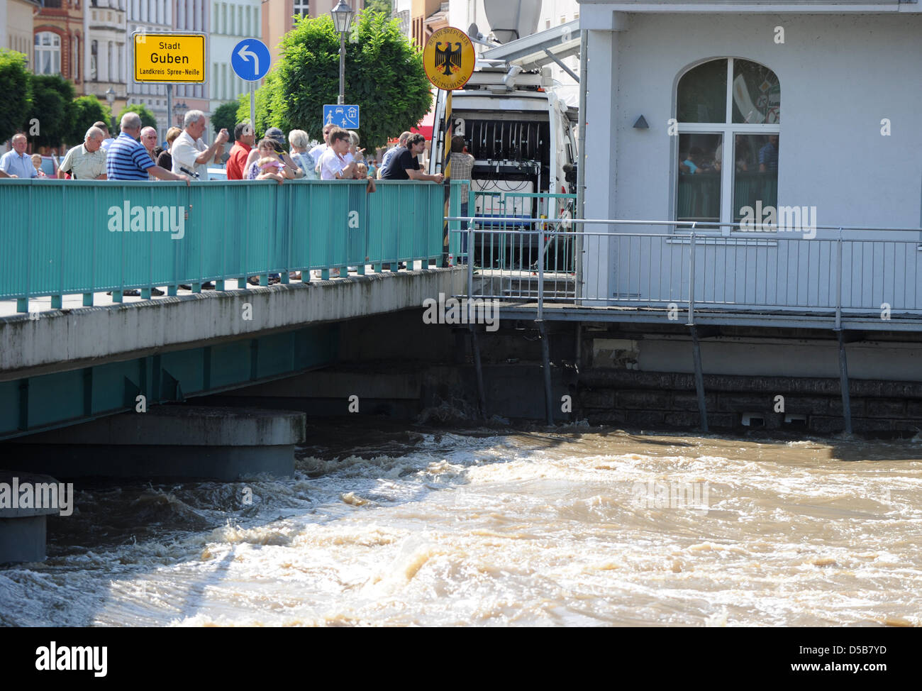 Spectators look at the high water of river Nysa at a bridge in the ...