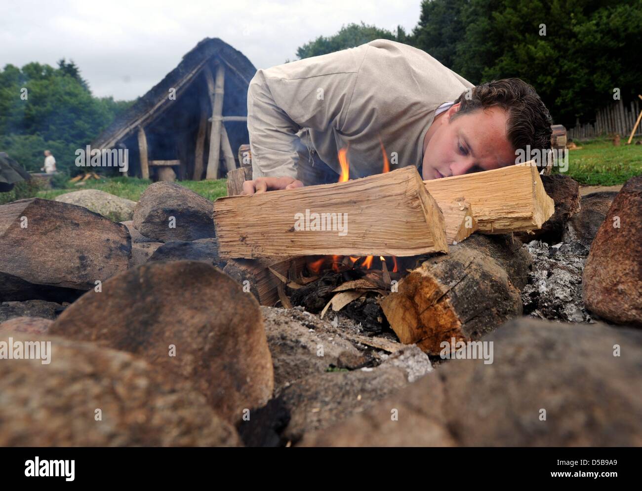 A student makes fire in the so-called Stone Age village Albersdorf ...
