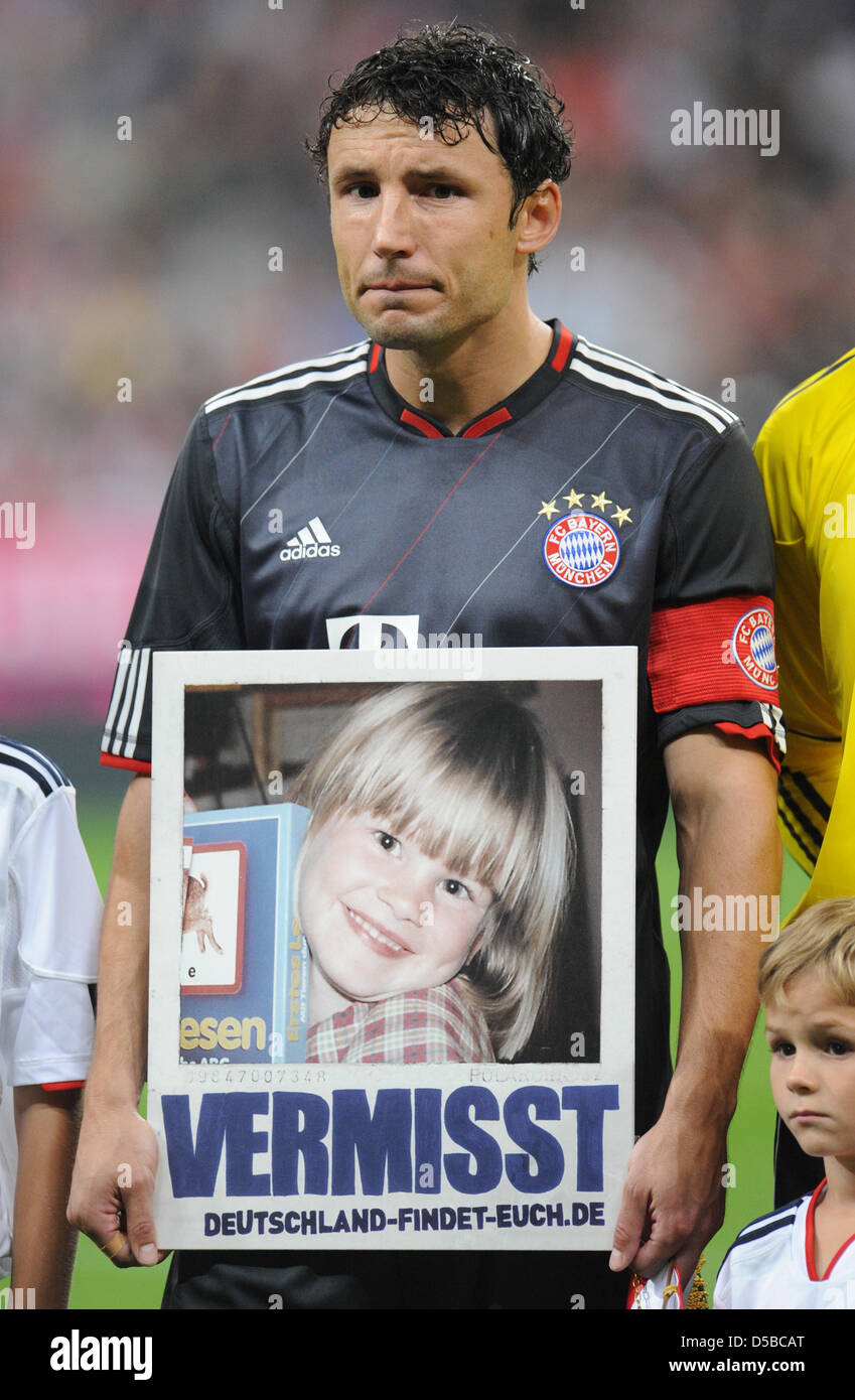 Bayern Munich's captain Mark van Bommel holds a picture of a missed ...