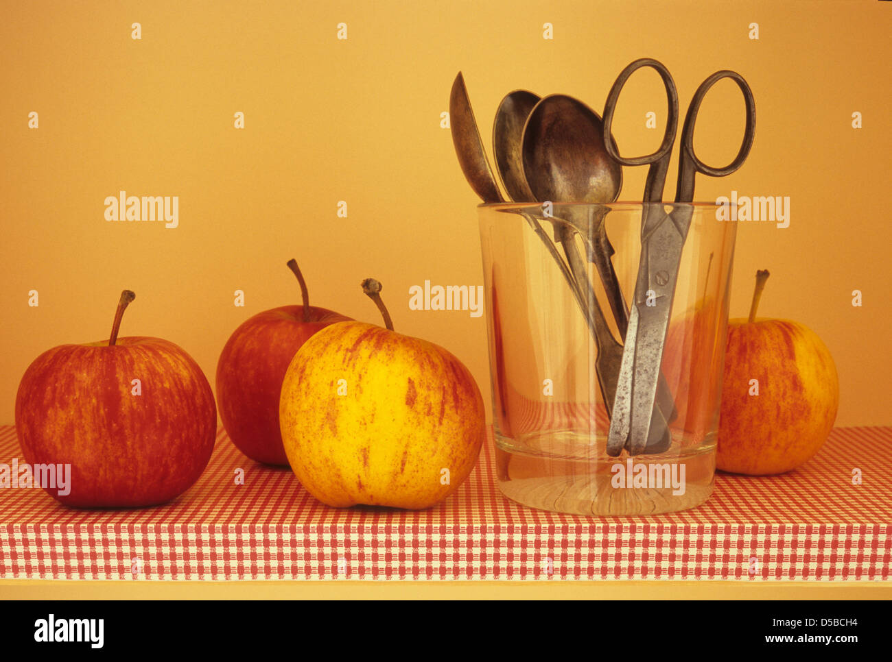 Eye-level view of narrow shelf with four red and yellow apples and ...