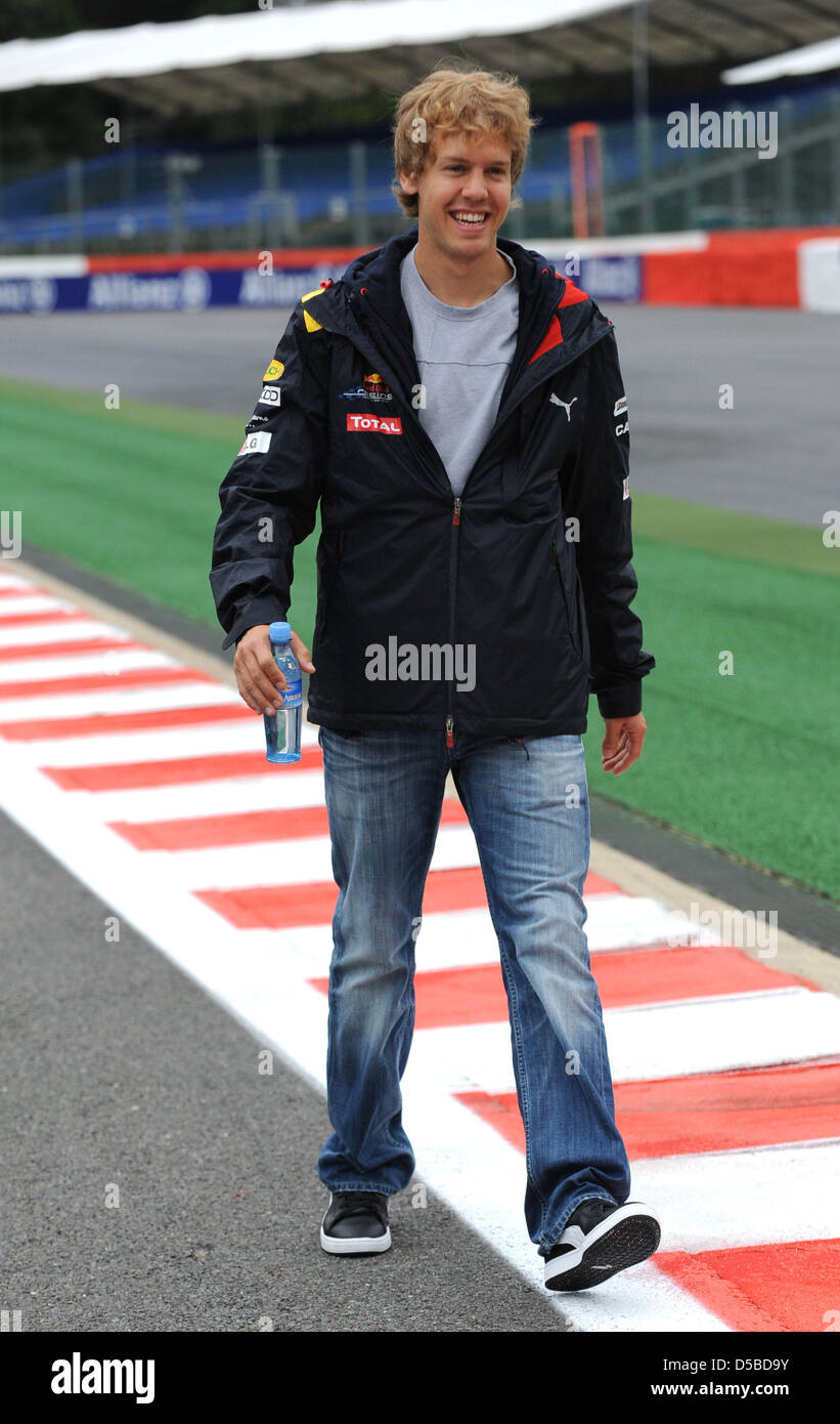 German driver Sebastian Vettel of Red Bull walks across the circuit in ...