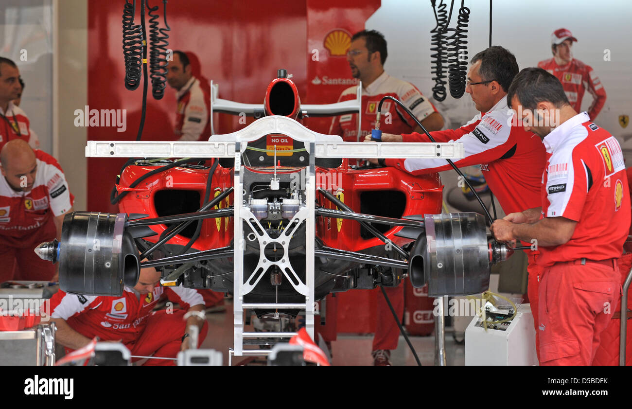 Ferrari mechanics work on Fernando Alonso's racecar in Spa ...