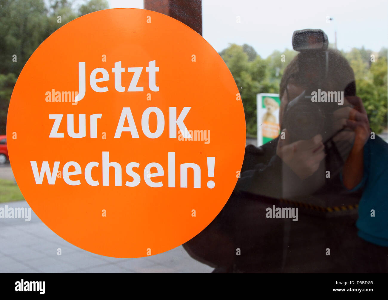 A photographer takes a picture of his reflection in a window of the AOK ...