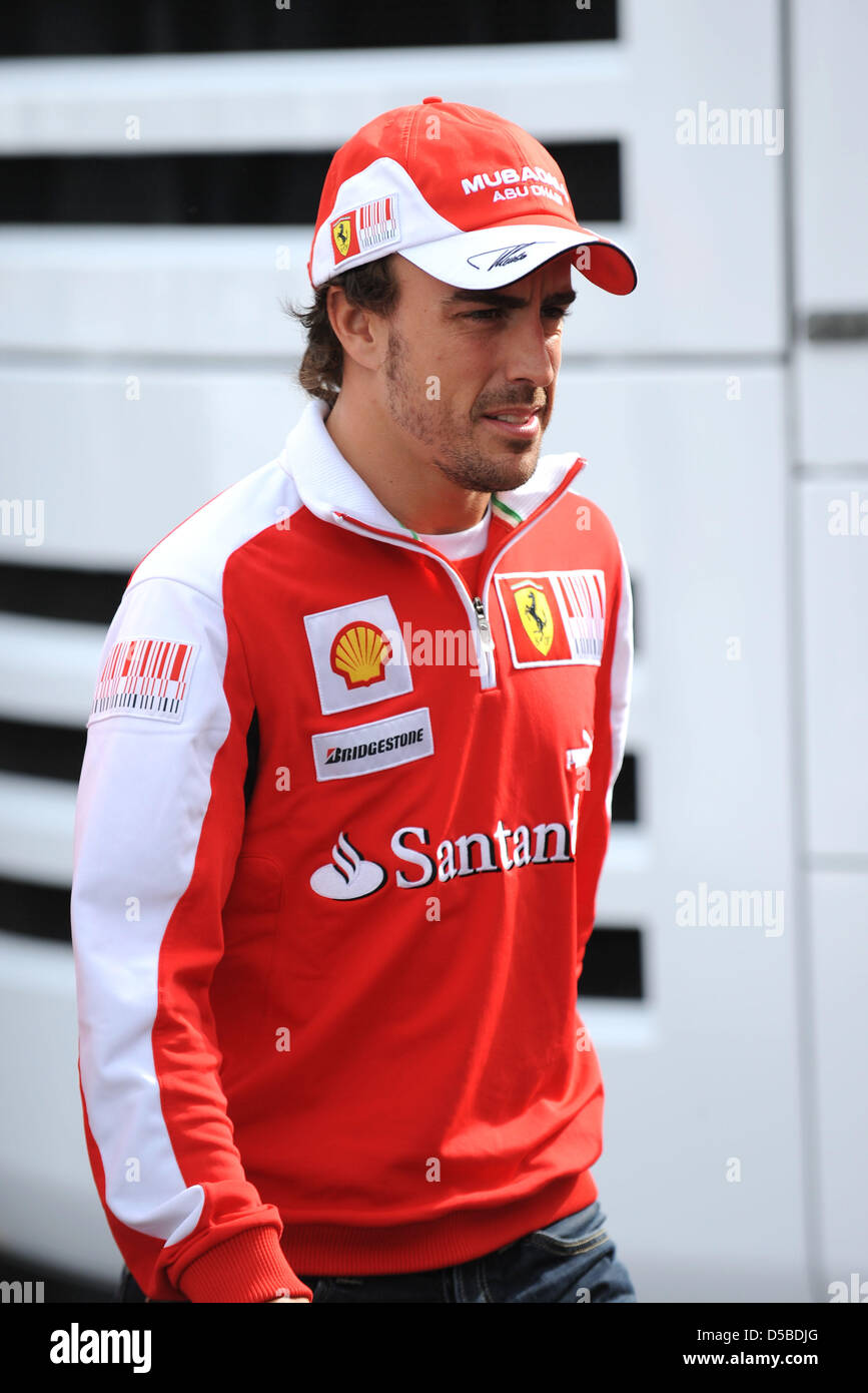 SPanish driver Fernando Alonso of Ferrari walks through the paddock in ...