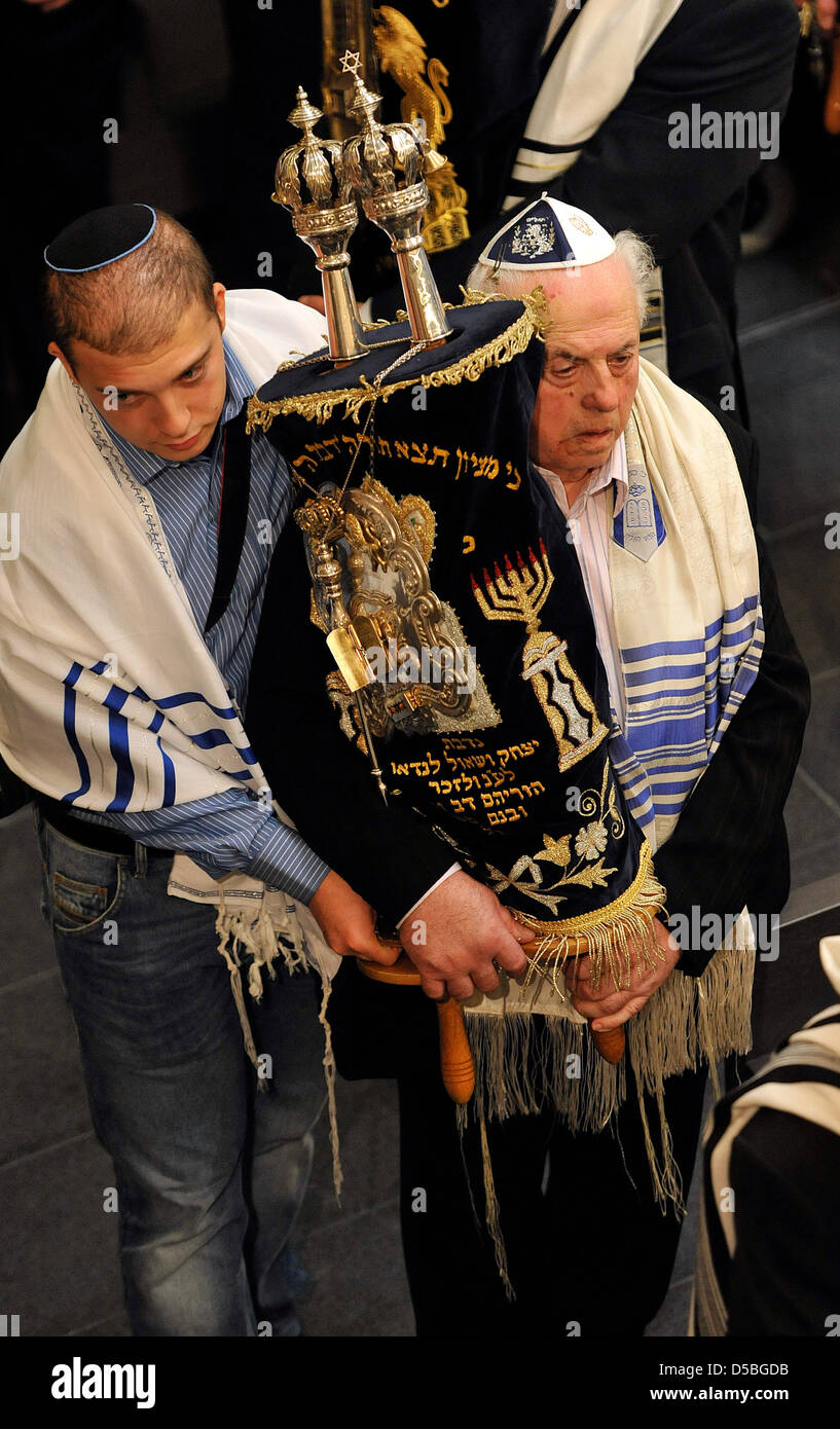 Parishioners carry Torah scrolls into the new synagogue during a ...