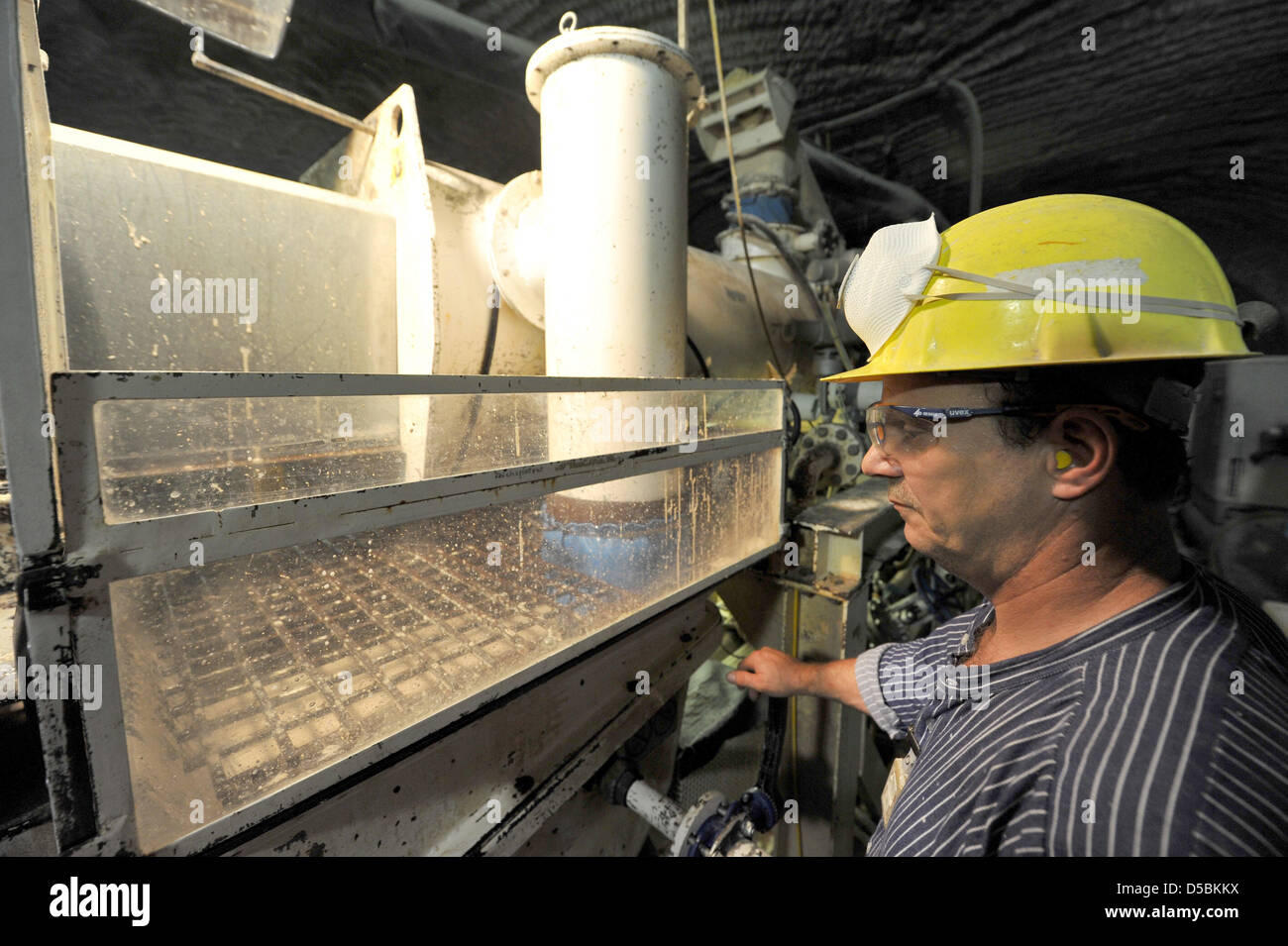A worker supervises the concrete mixer during preparatory works for the ...