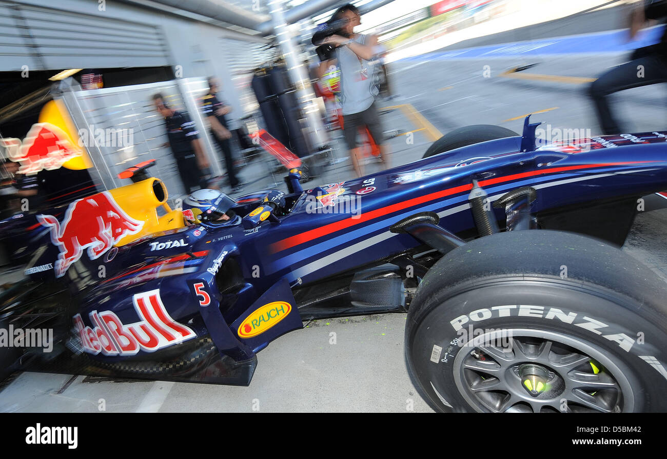 German driver Sebastian Vettel of Red Bull drives out of his pit during ...